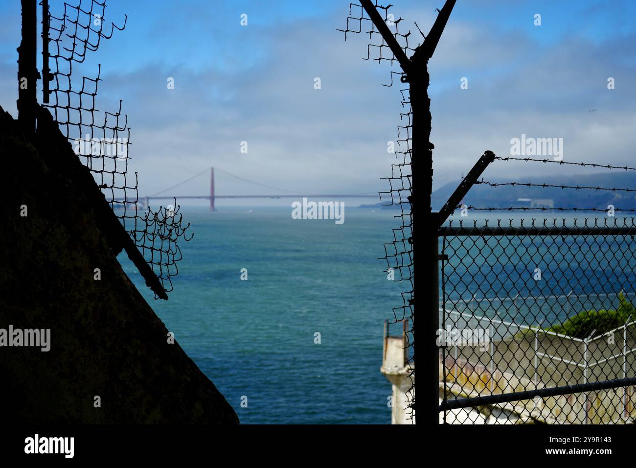 View of The Golden Gate Bridge through a silhouette of broken fencing ...