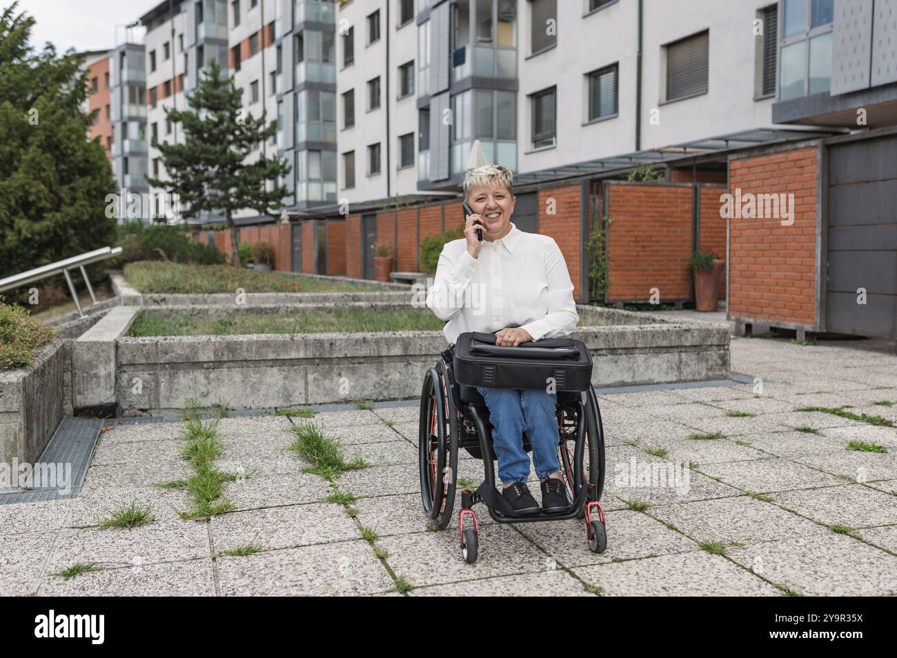 Smiling business lady with disability, a wheelchair user talking on a ...