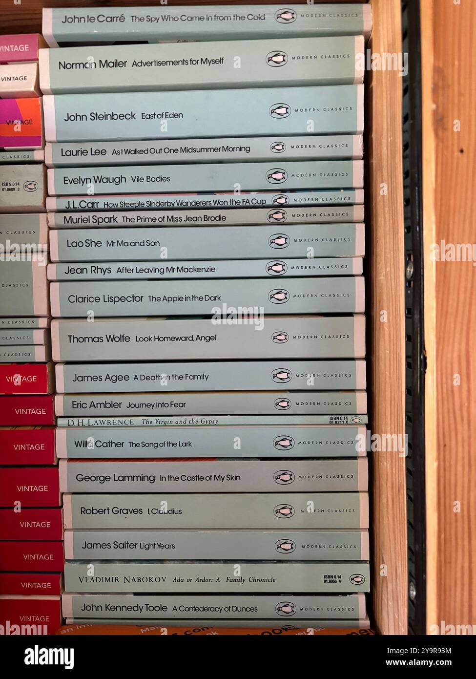 Penguin Modern Classics novels piled horizontally on bookshelf Stock ...
