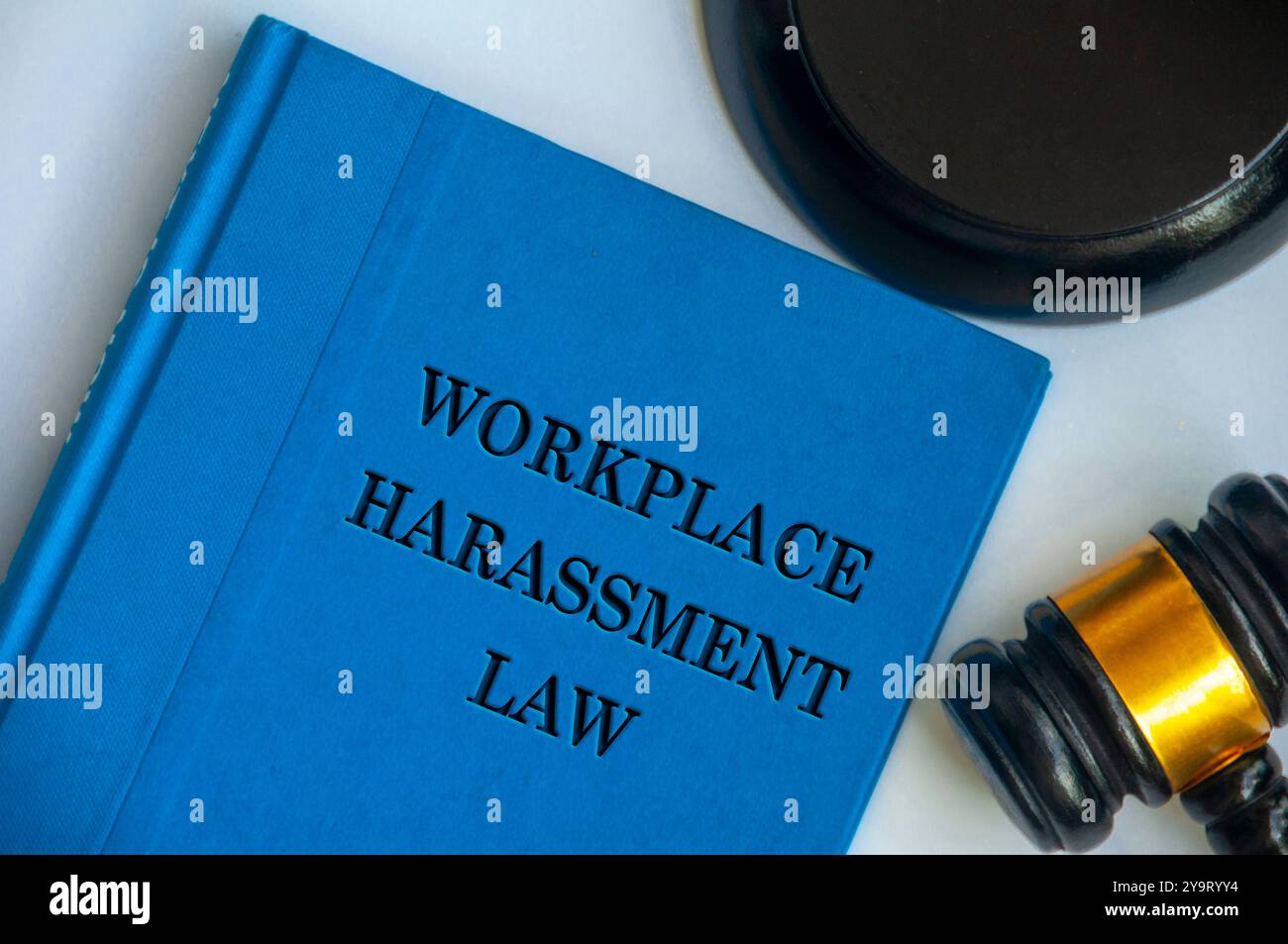 Top view of Workplace Harassment Policy blue book with gavel on white ...