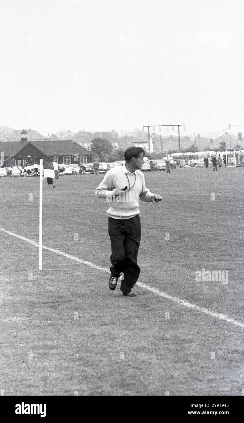 1960, historical, male referee with whistle on the line on a game of ...