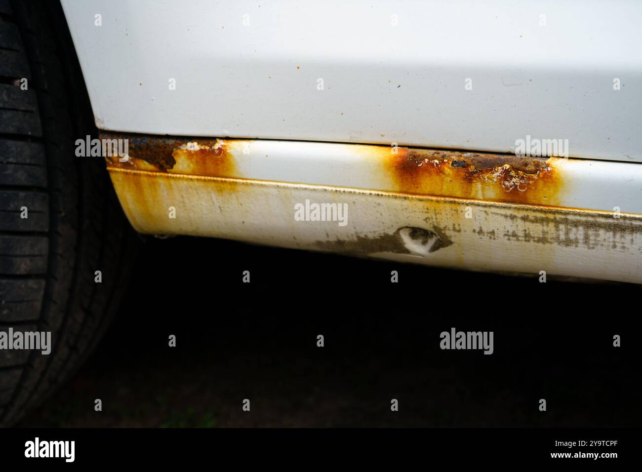 Rust spots on the side of a white vehicle parked outdoors Stock Photo ...