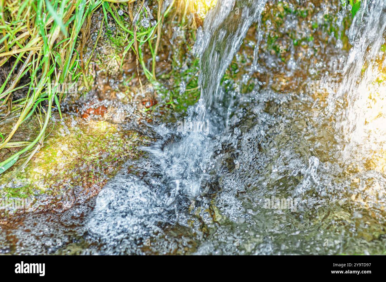 Splashes and bubbles in stream of clean fresh spring water in forest ...