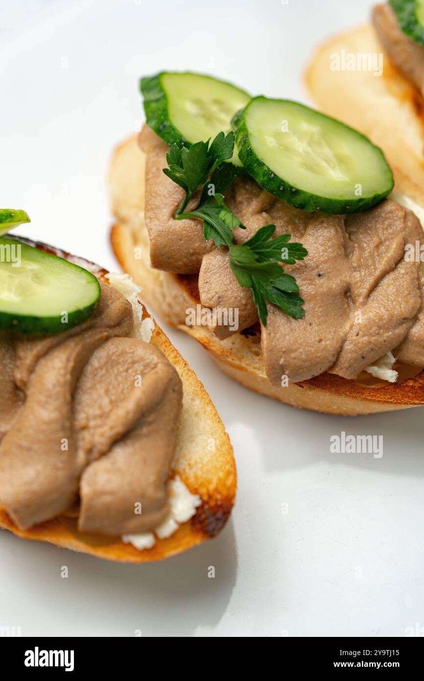 Savory canapes topped with creamy spread and cucumber slices served on ...