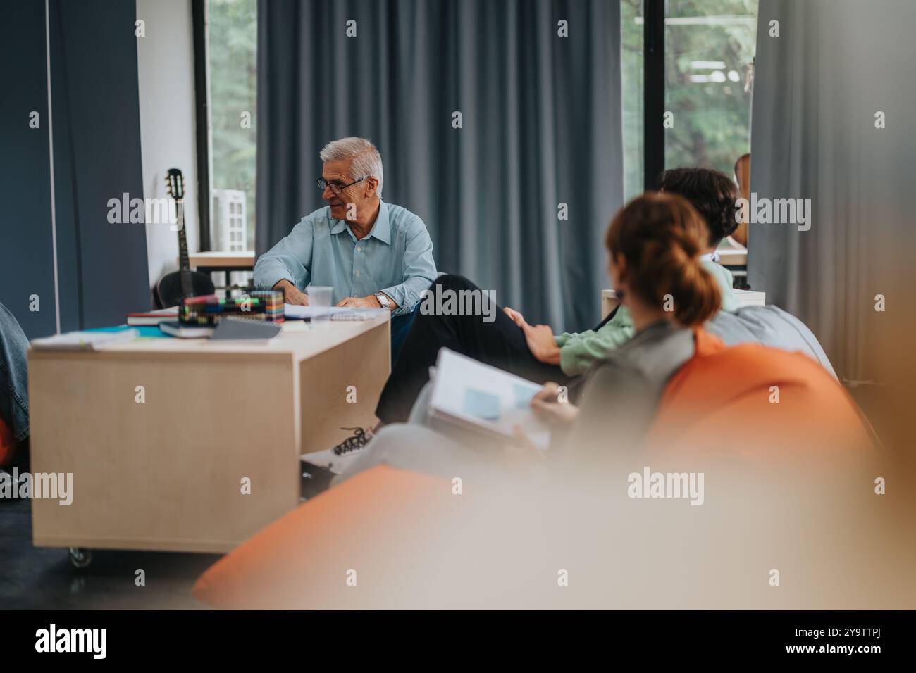 Professor engaging with students in relaxed classroom setting Stock ...