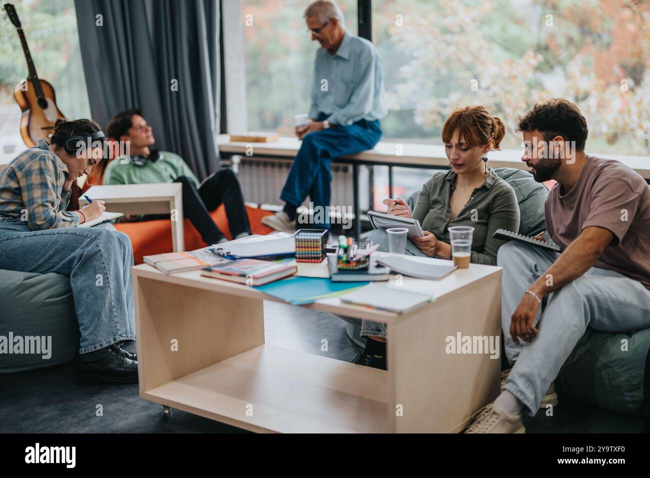 Professor engaging with attentive students in relaxed classroom setting ...