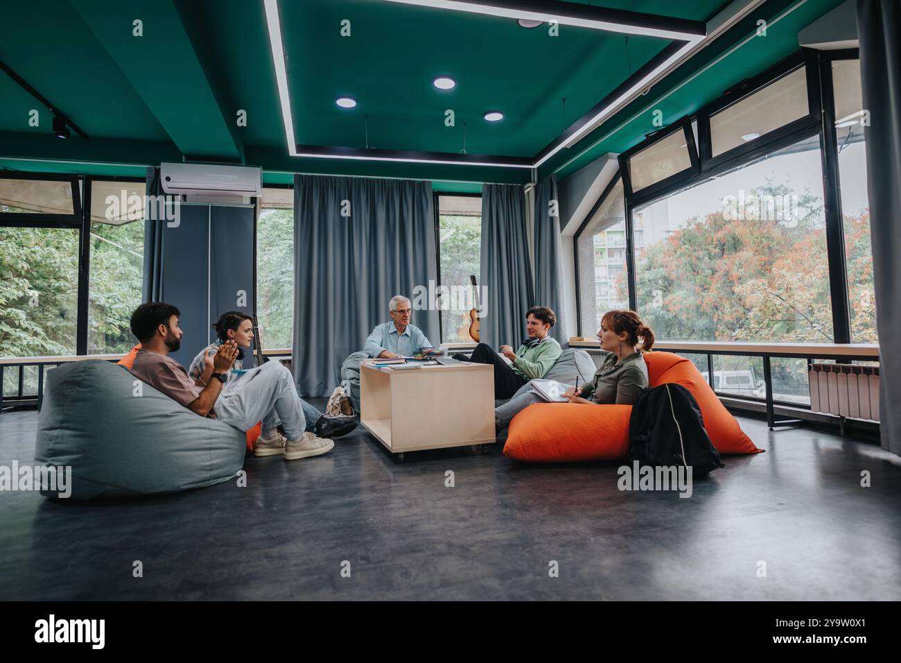 Professor engaging with students in modern study lounge Stock Photo - Alamy