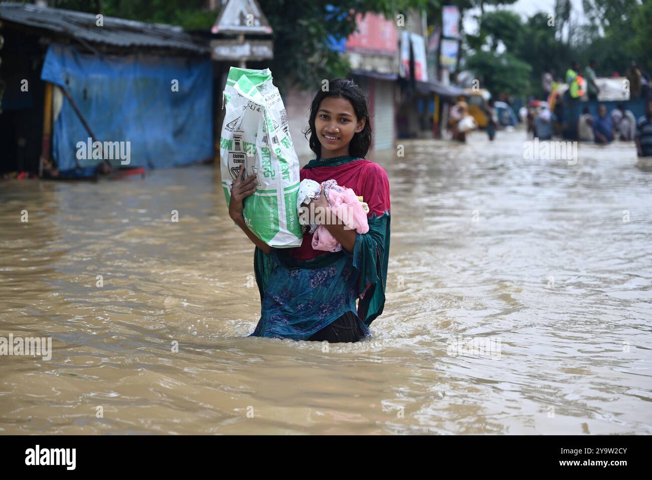 People wade through floodwaters in Feni District, Bangladesh, on August ...