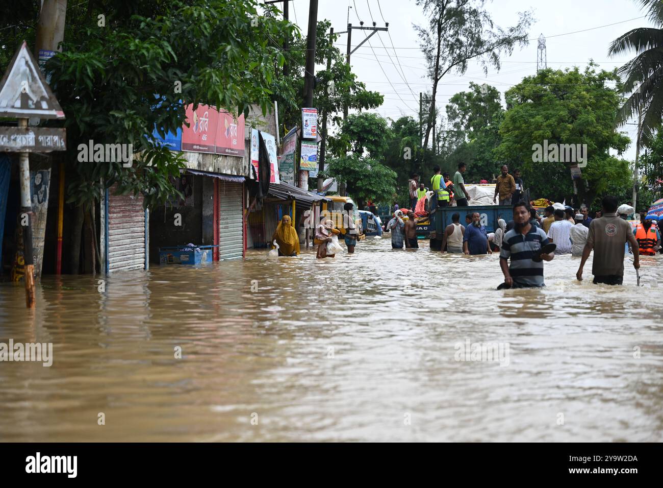 People wade through floodwaters in Feni District, Bangladesh, on August ...