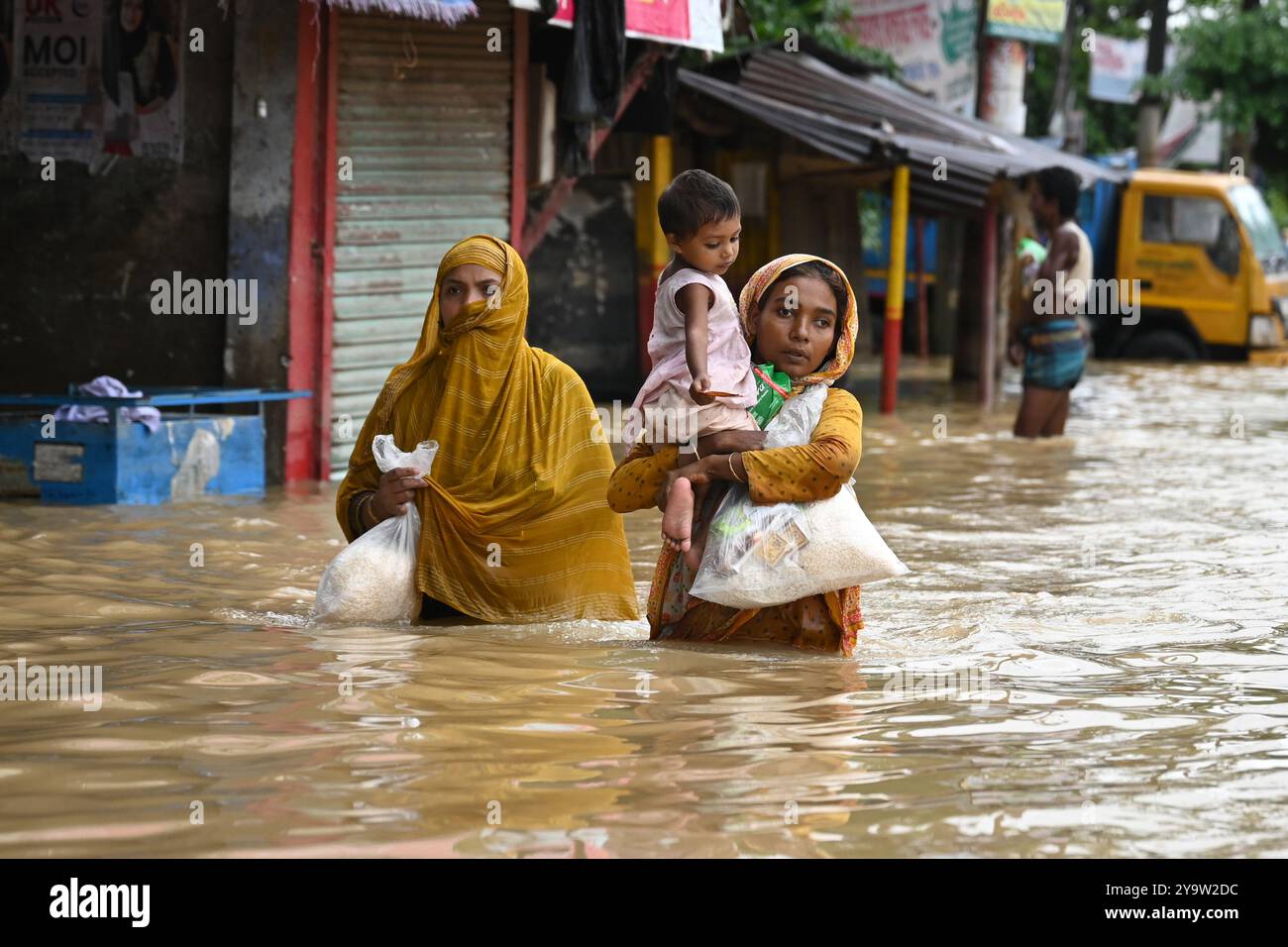 People wade through floodwaters in Feni District, Bangladesh, on August ...