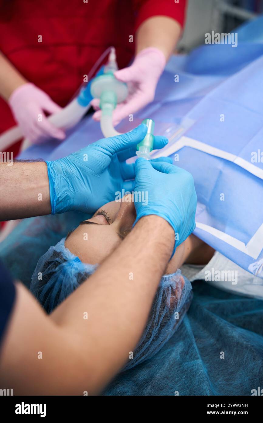 Experienced anesthesiologist works in an operating room with female ...