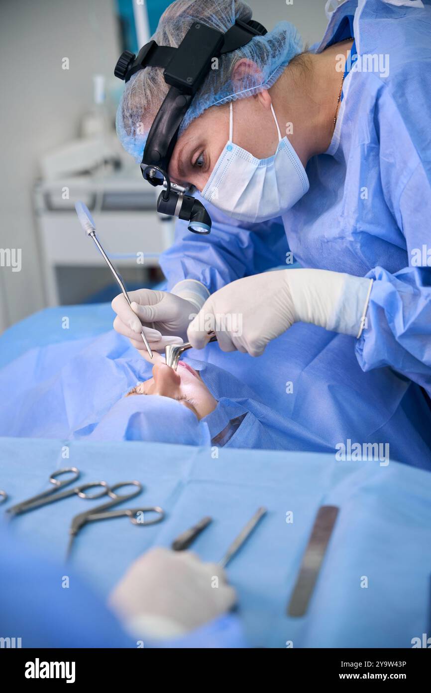 Female otolaryngologist surgeon performs a maxillary antrotomy in a ...