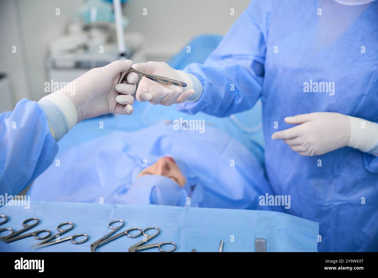 Surgical nurse hands a metal instrument to a doctor Stock Photo - Alamy