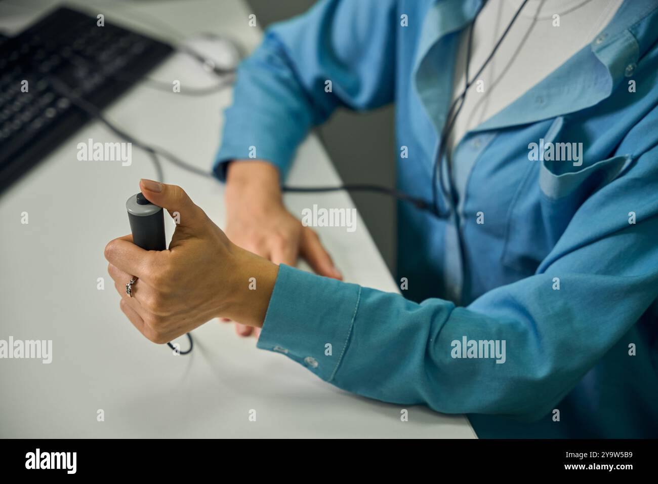 Patient holding response button during hearing test Stock Photo - Alamy