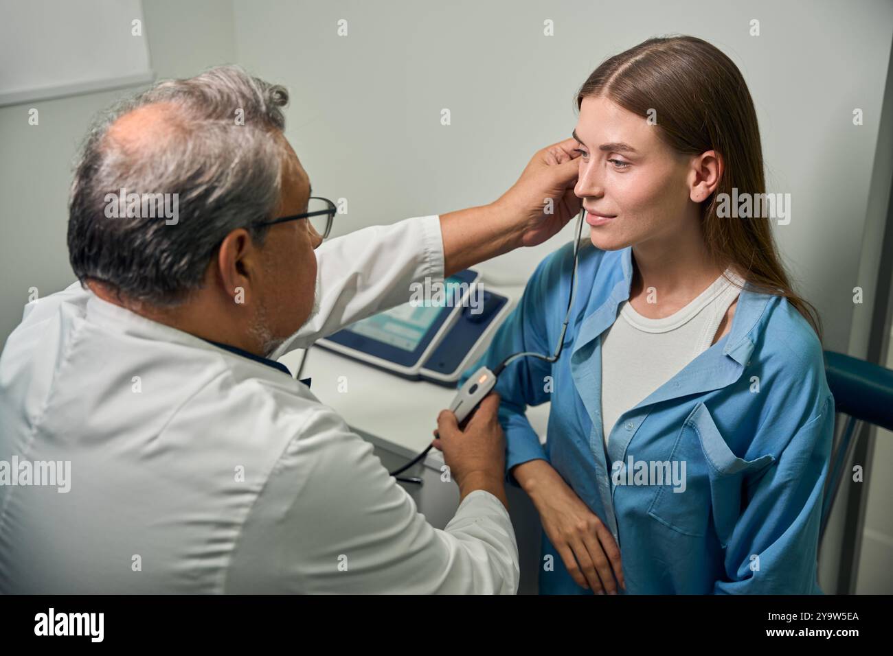 Female patient receiving ear examination from doctor Stock Photo - Alamy