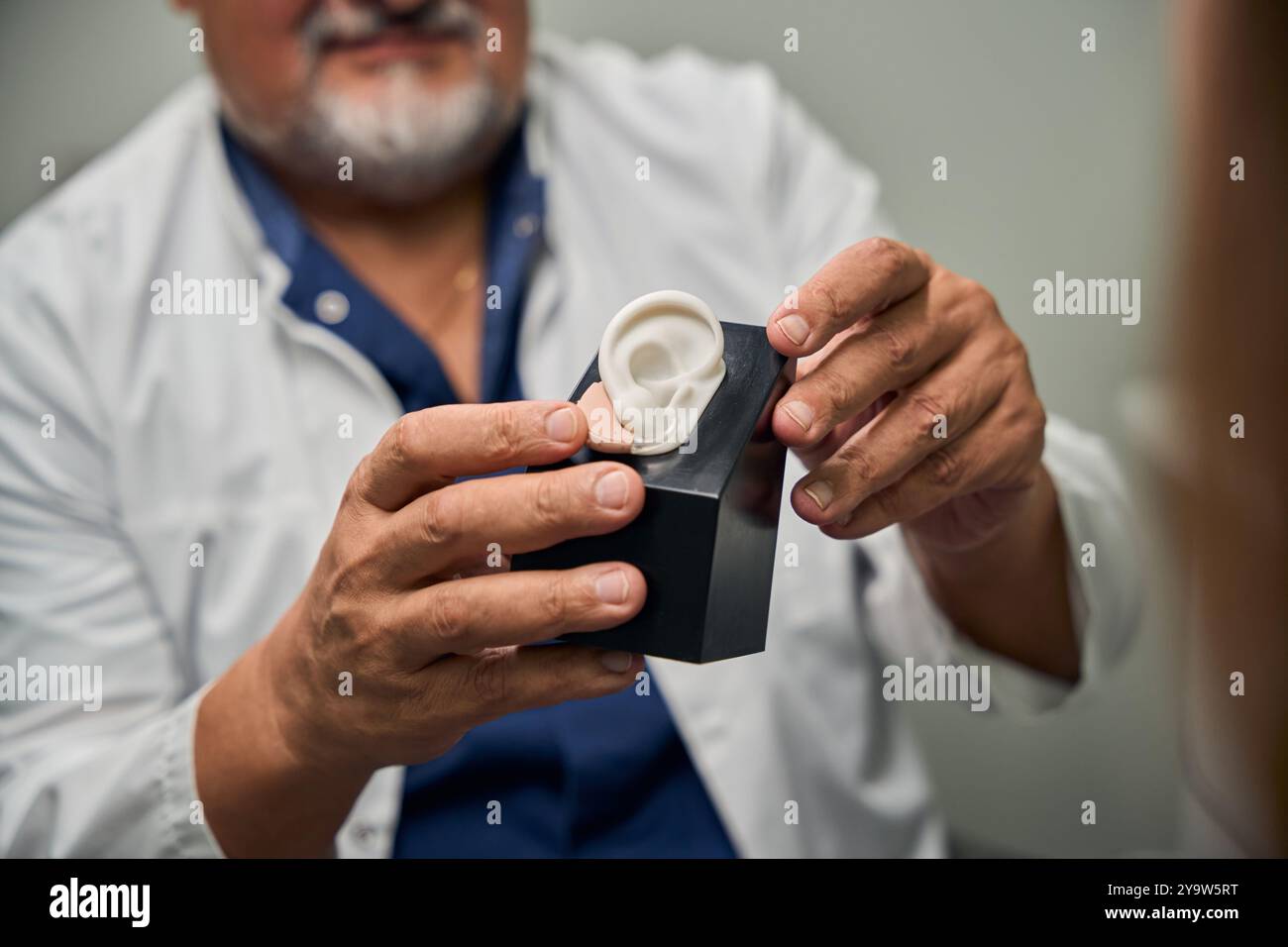 Doctor explaining hearing aid hi-res stock photography and images - Alamy