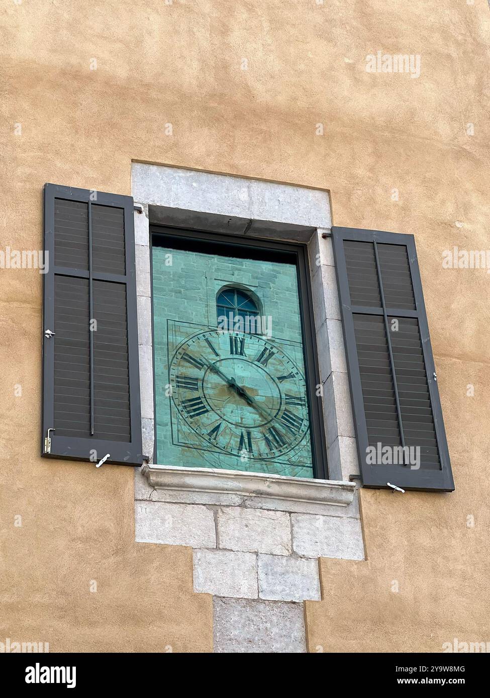 reflection clock face of Girona Cathedral in window of building Stock ...