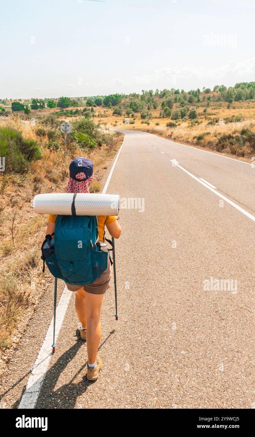 A pilgrim walking along a rural road on the Camino de Santiago. Spain ...