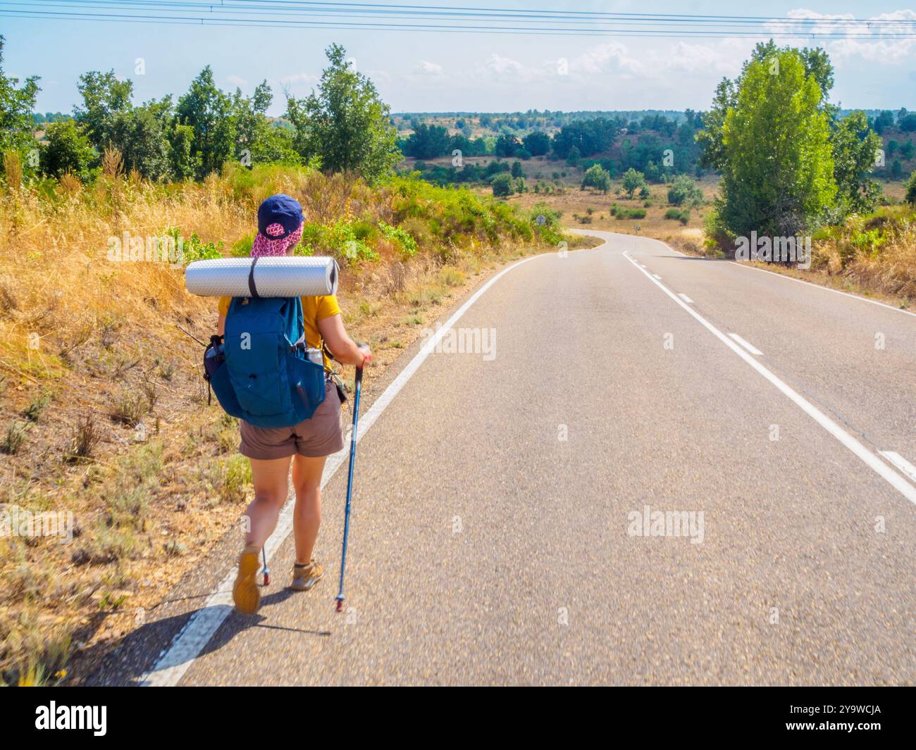 A pilgrim walking along a rural road on the Camino de Santiago. Spain ...