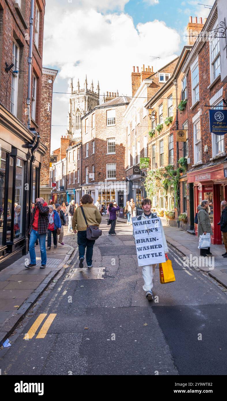 Male walking along the narrow streets with a protest board and dressed ...