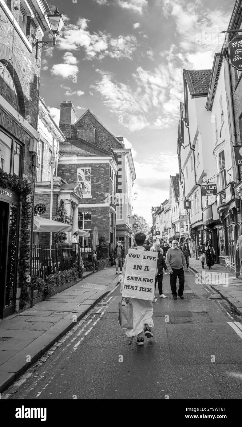 Male walking along the narrow streets with a protest board and dressed ...