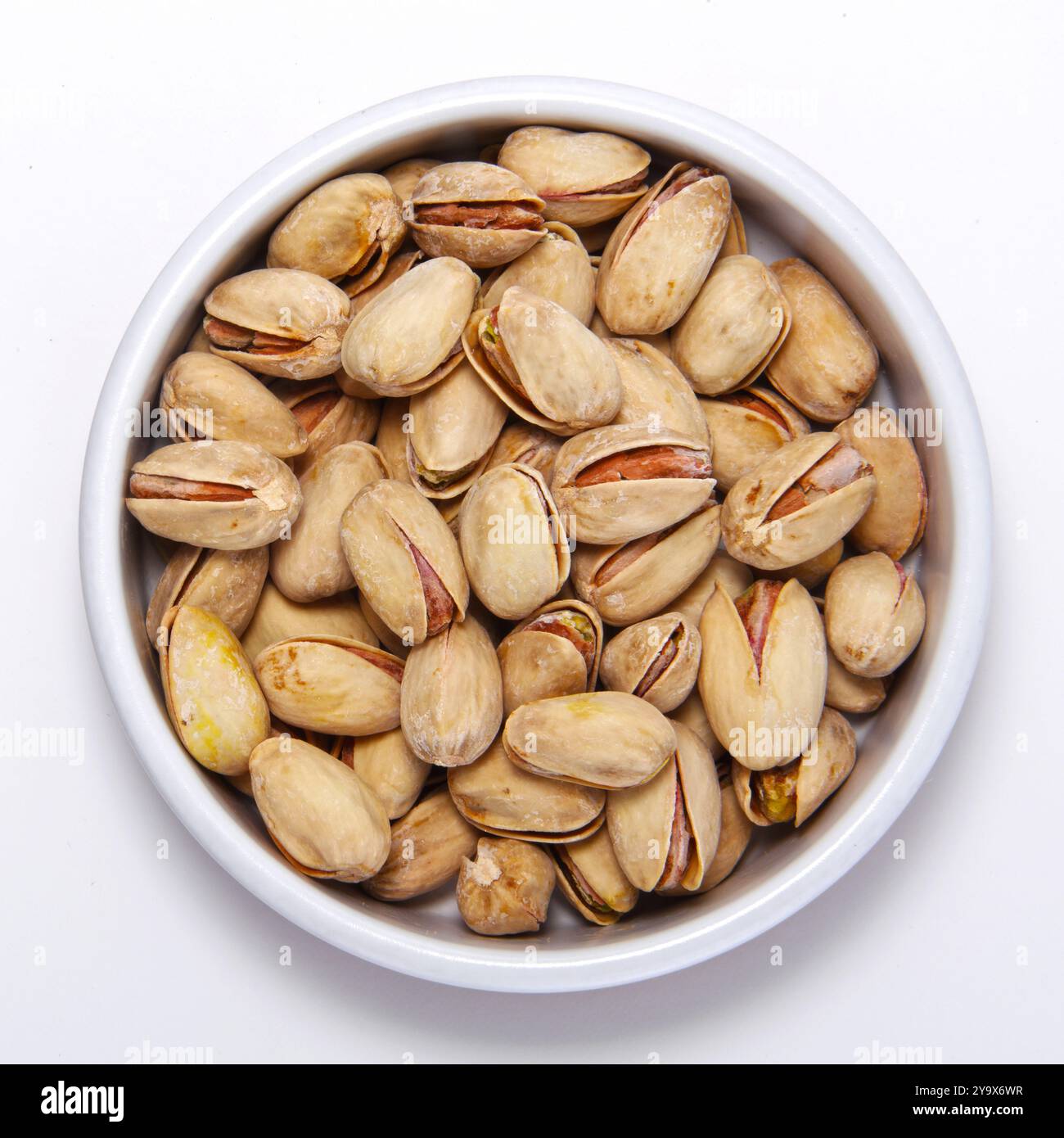 Pistachio nuts in shells in round container Stock Photo - Alamy