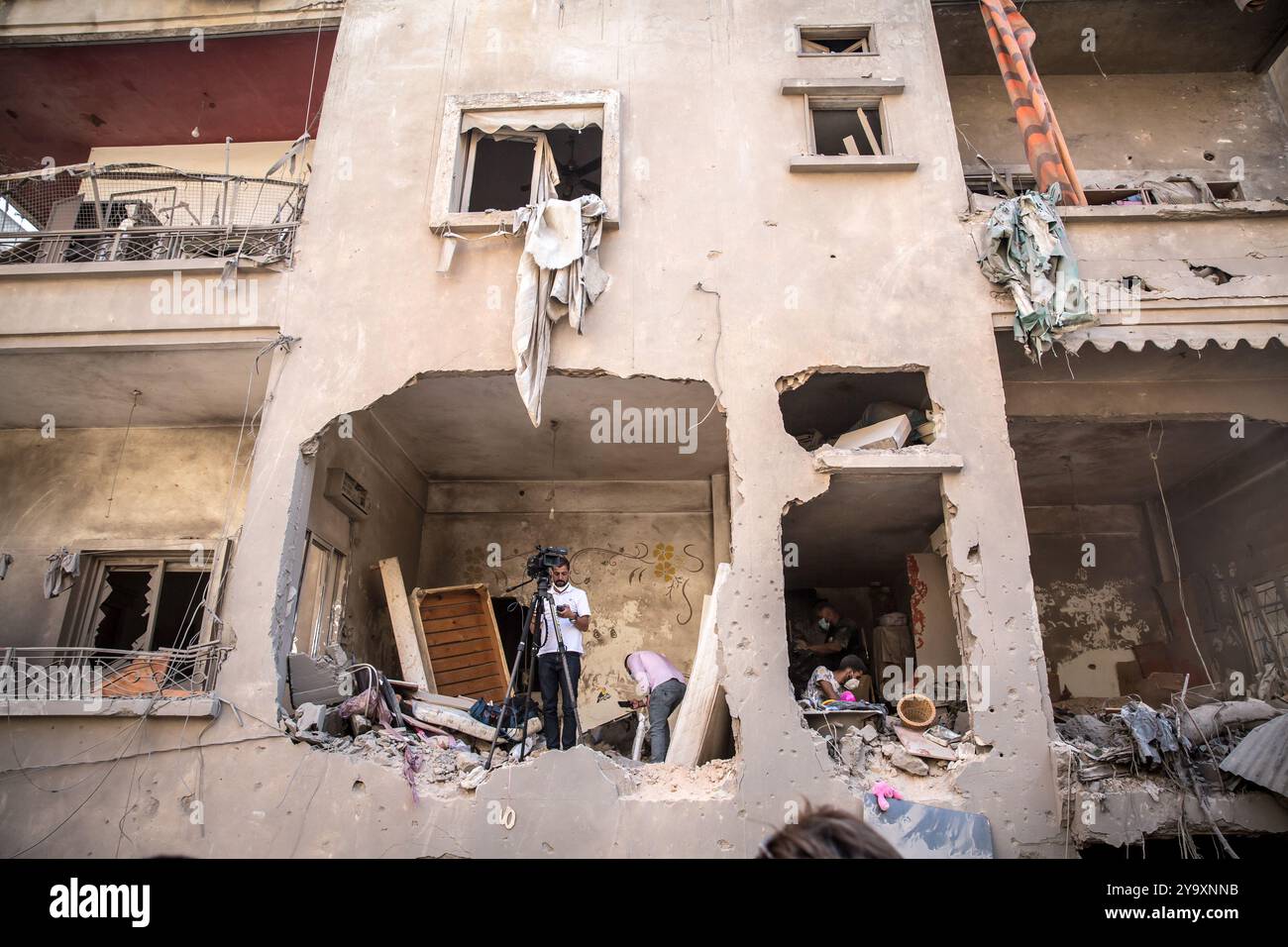 A journalist films after an Israeli air strike on Mamoun Street in the ...