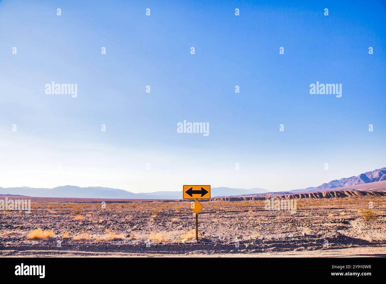 Direction sign in the desert under a blue sky. Concept of uncertain ...