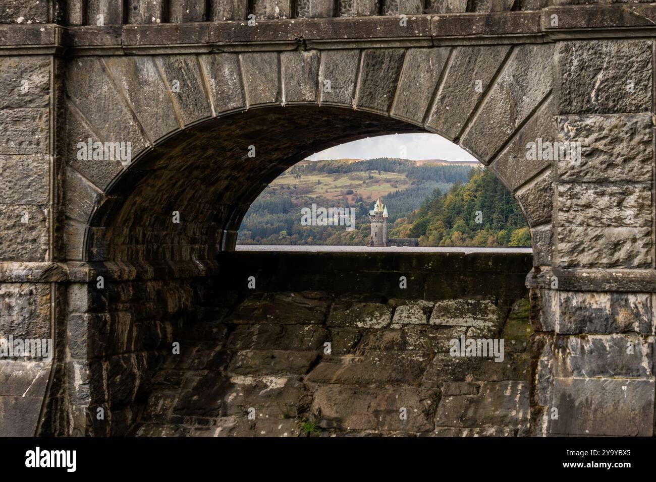 Stone archway framing the iconic water tower at llyn vyrnwy reservoir ...