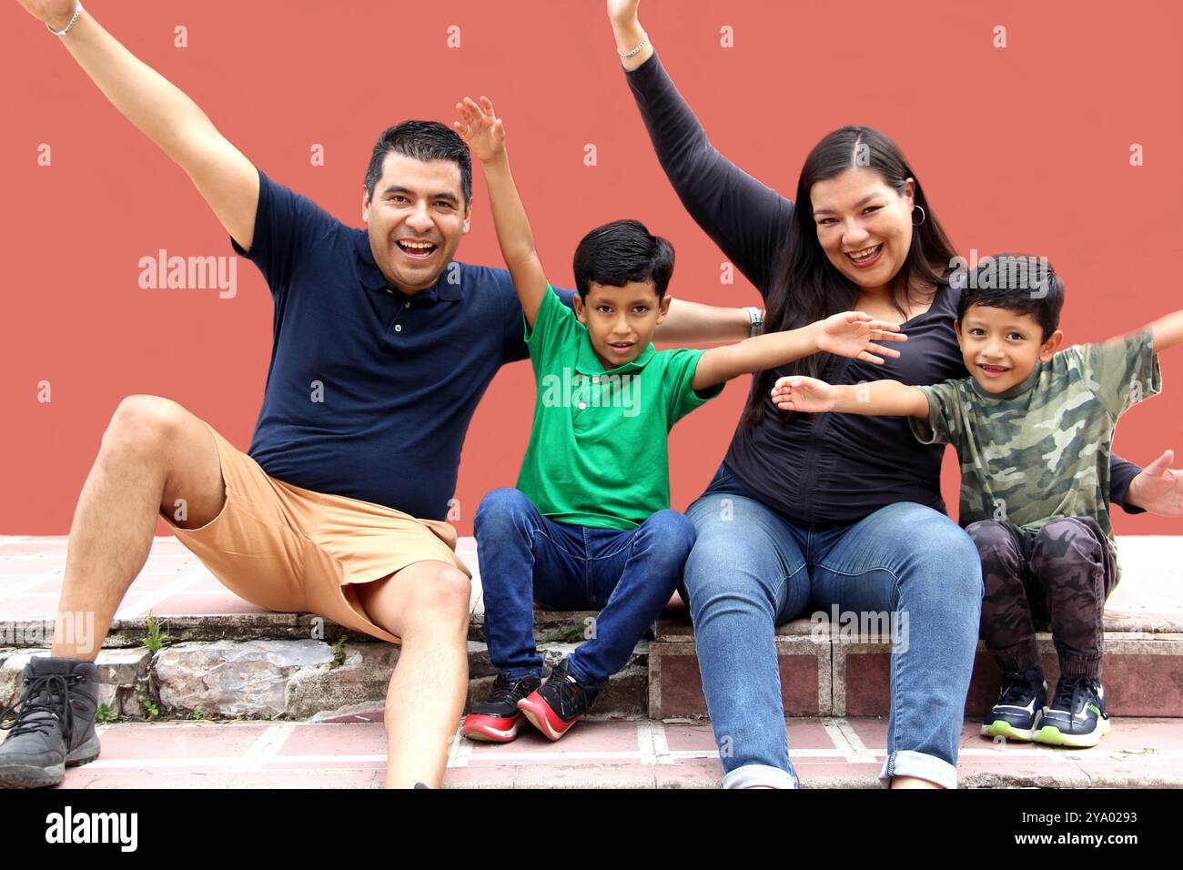 Latin, Hispanic family of mom, dad and children are sitting in the park ...