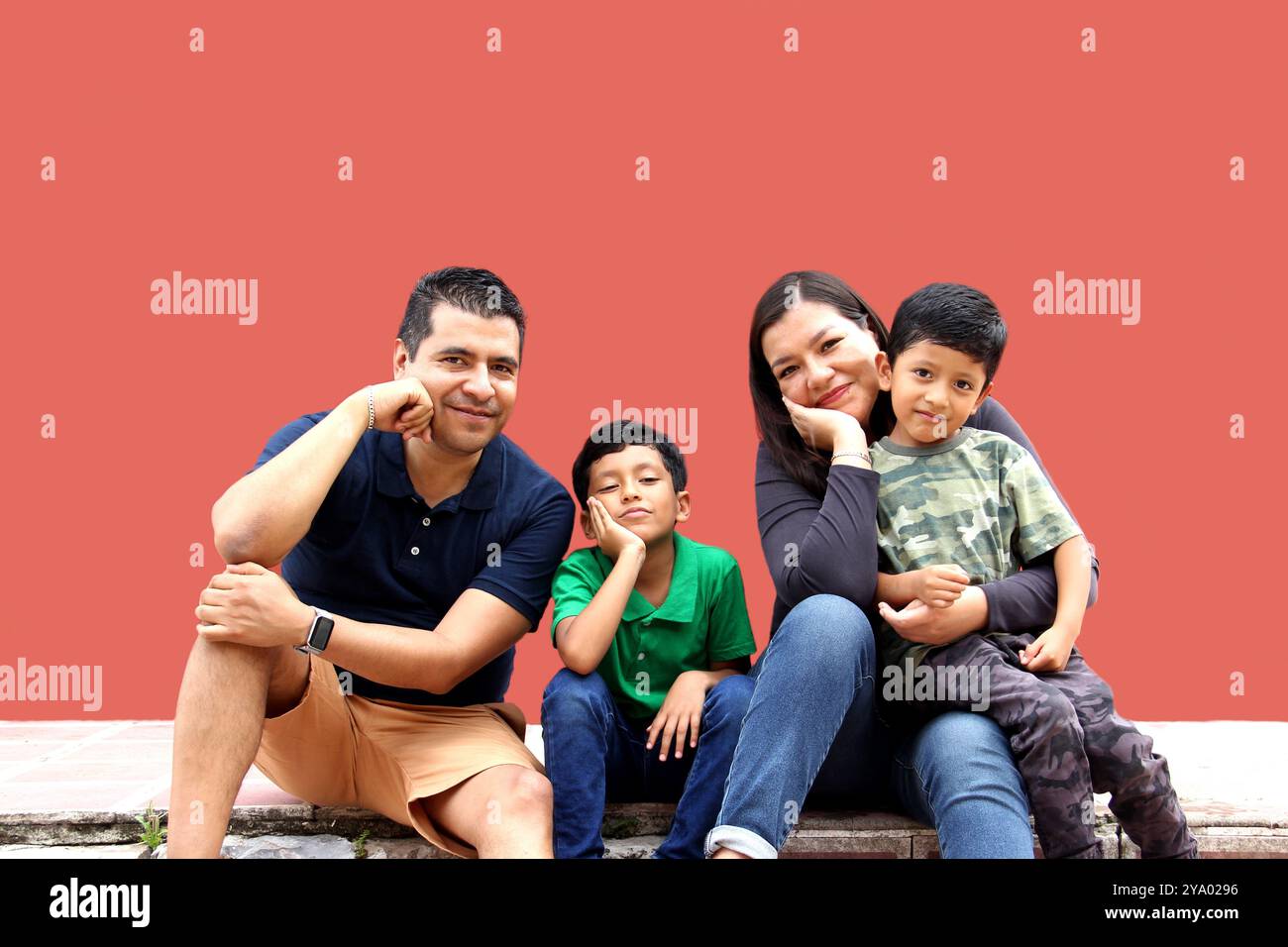 Latin, Hispanic family of mom, dad and children are sitting in the park ...