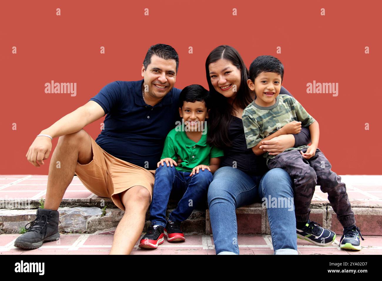 Latin, Hispanic family of mom, dad and children are sitting in the park ...