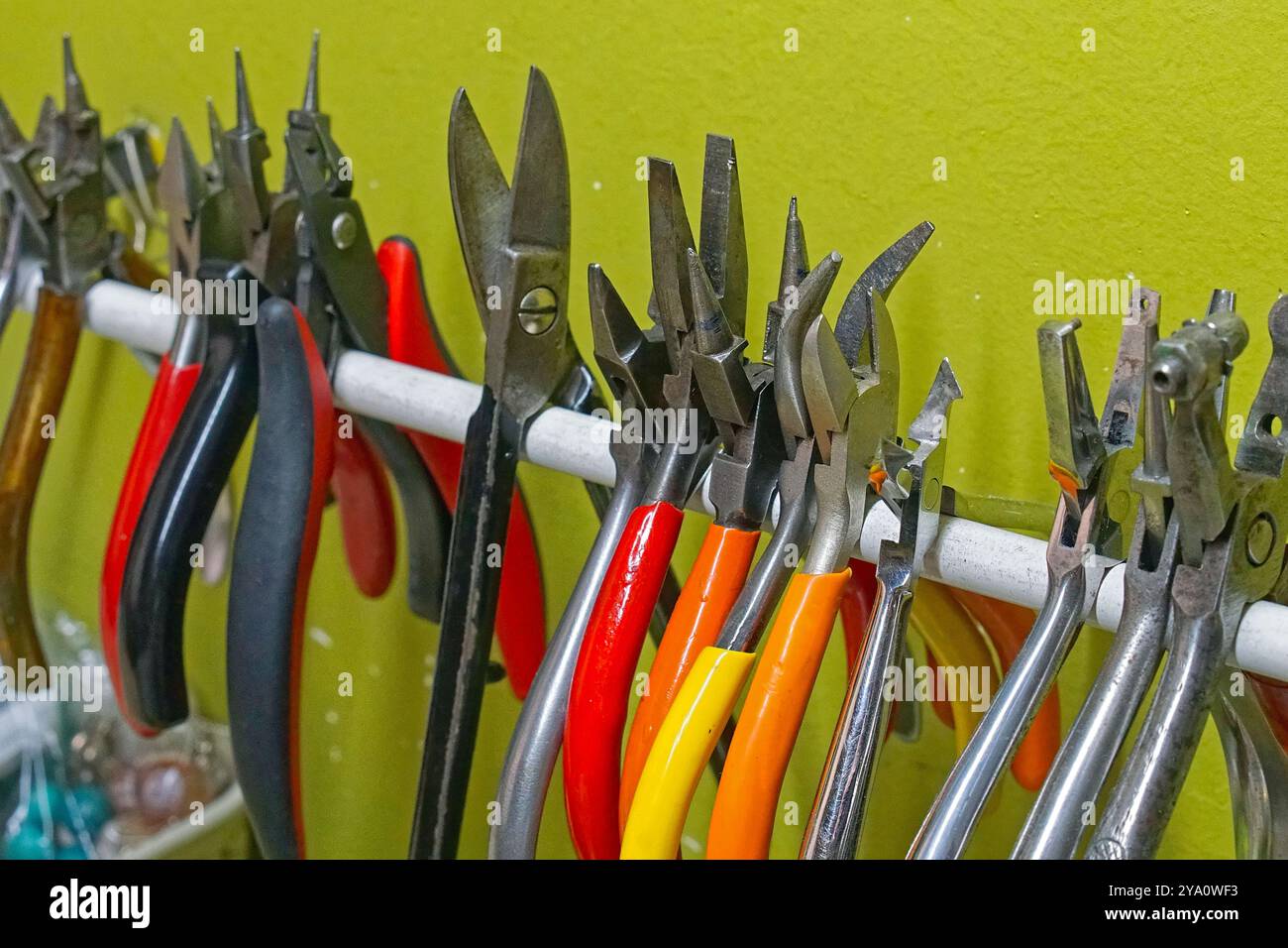 Collection of various size and shape pliers craft hand tools at rail ...