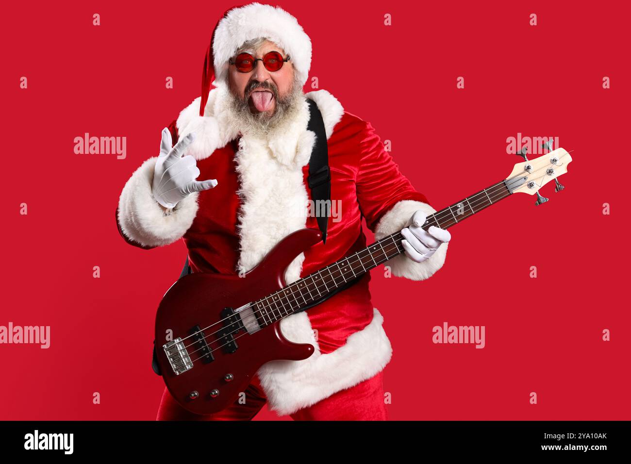Cool Santa Claus with guitar showing "devil horns" gesture on red ...