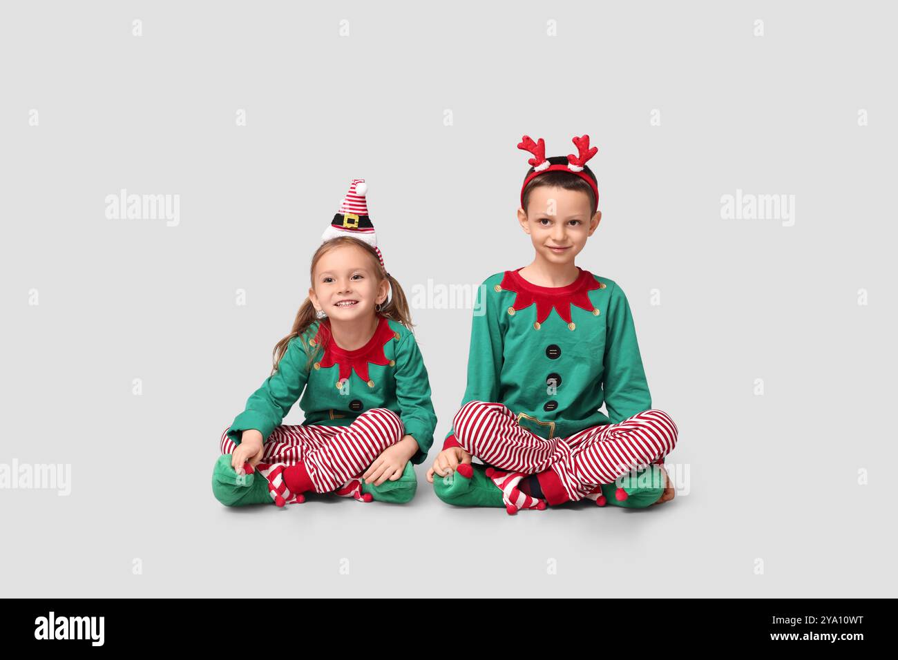 Cute little children dressed as elves on grey background Stock Photo ...