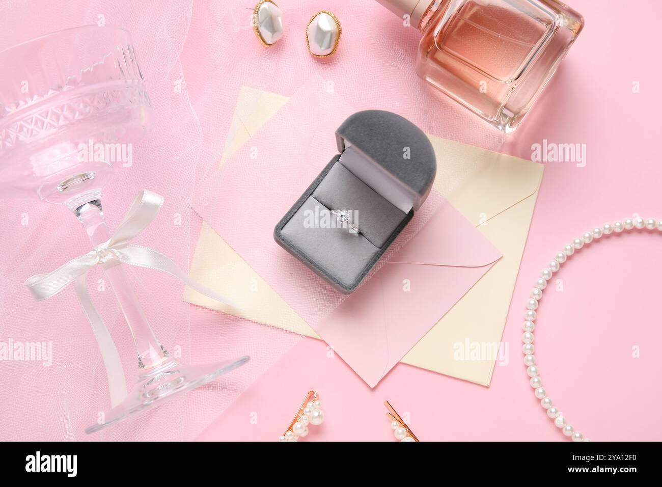 Engagement ring with envelopes and bride's accessories on pink ...