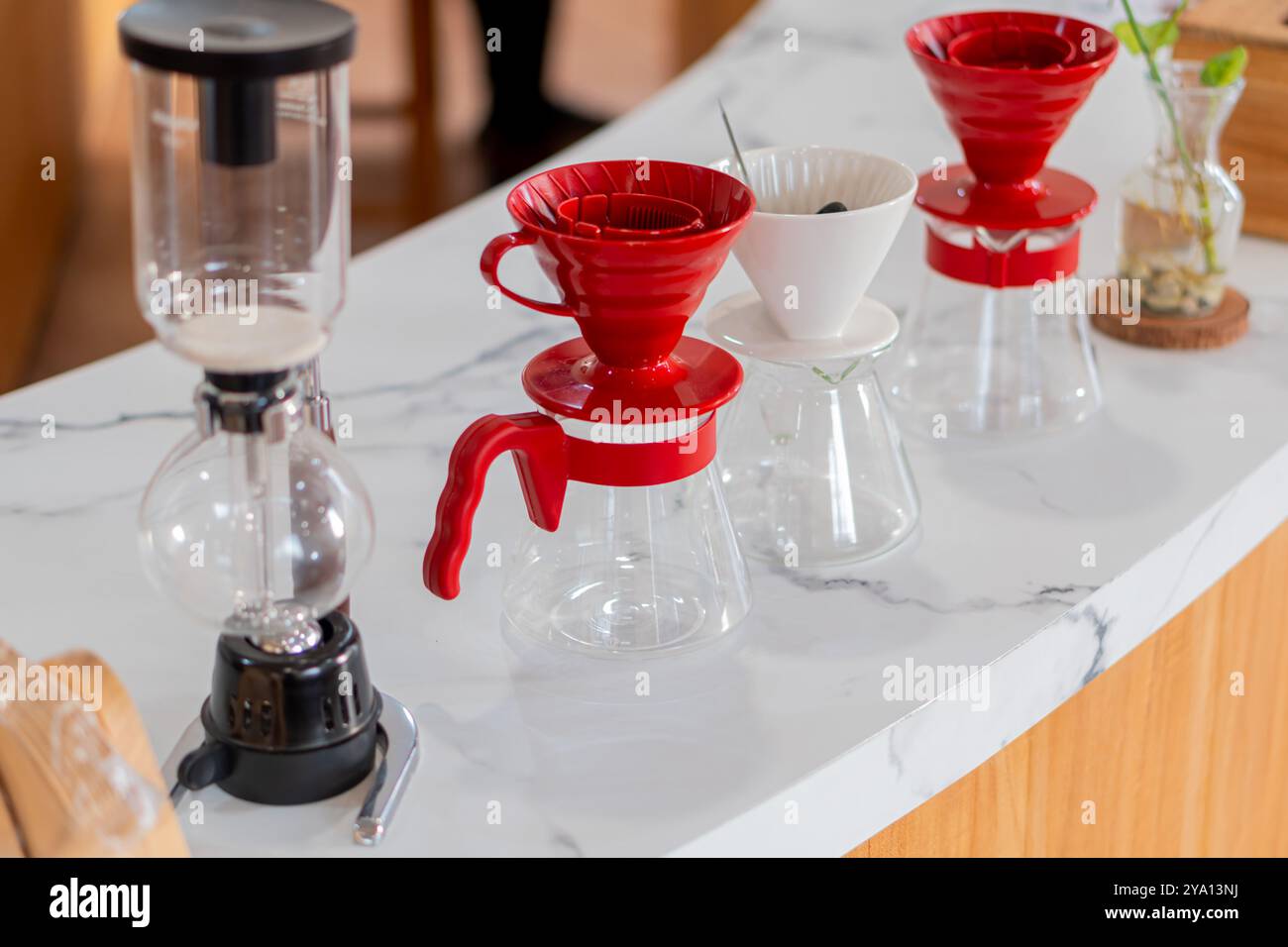 A stylish coffee brewing setup featuring a red pour-over coffee maker ...