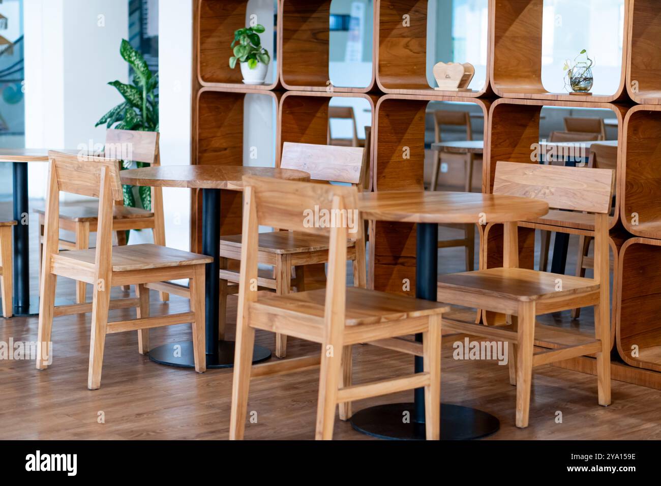 A modern cafe interior featuring wooden tables and chairs. The design ...