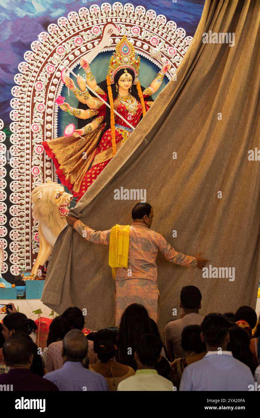 A priest opens the curtain of a tableau depicting an idol of Hindu ...