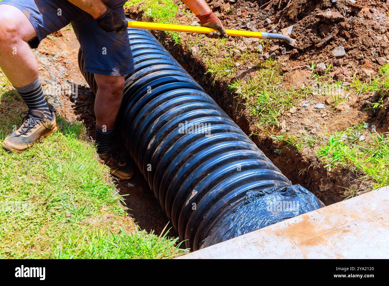 Installation of drainage black pipes in trench during construction ...