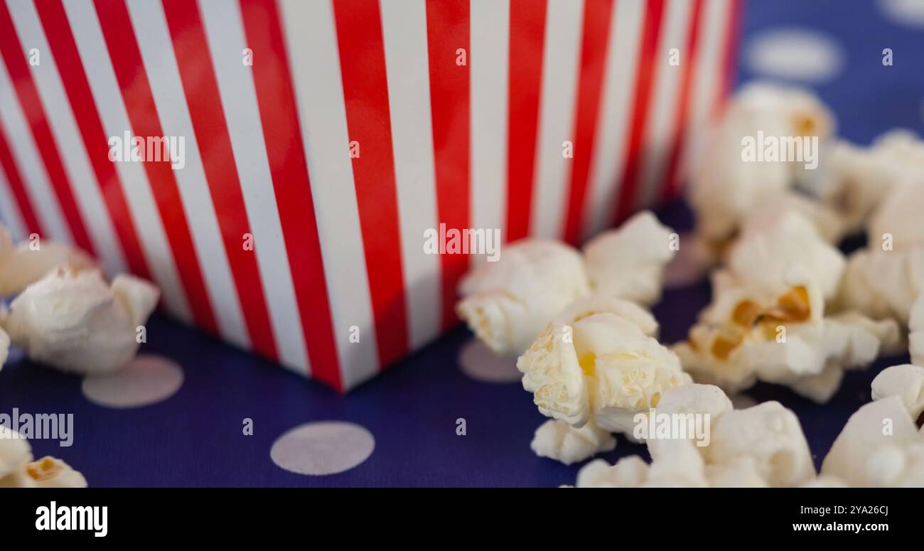 Image of box of popcorn over white spots. national popcorn day and ...