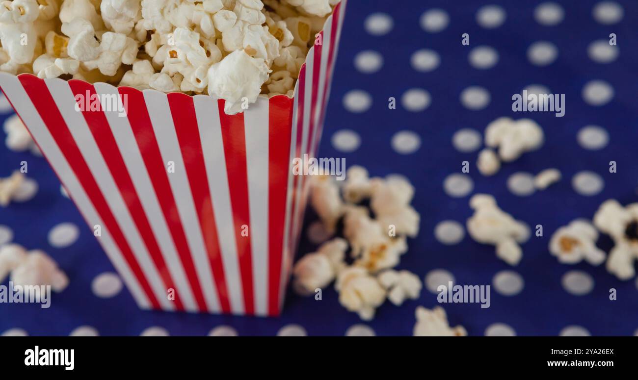 Image of box of popcorn over white spots. national popcorn day and ...