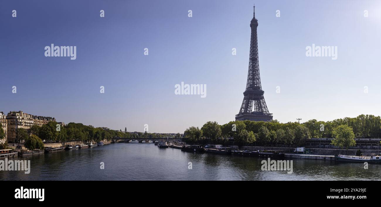 The Eiffel Tower on the banks of the Seine under a clear blue sky ...