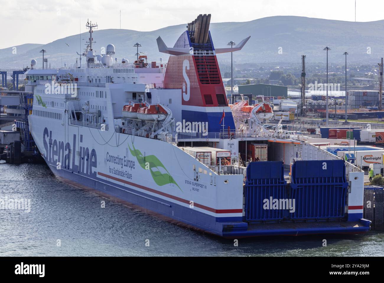 Large ferry in the harbour ready for loading or unloading surrounded by ...