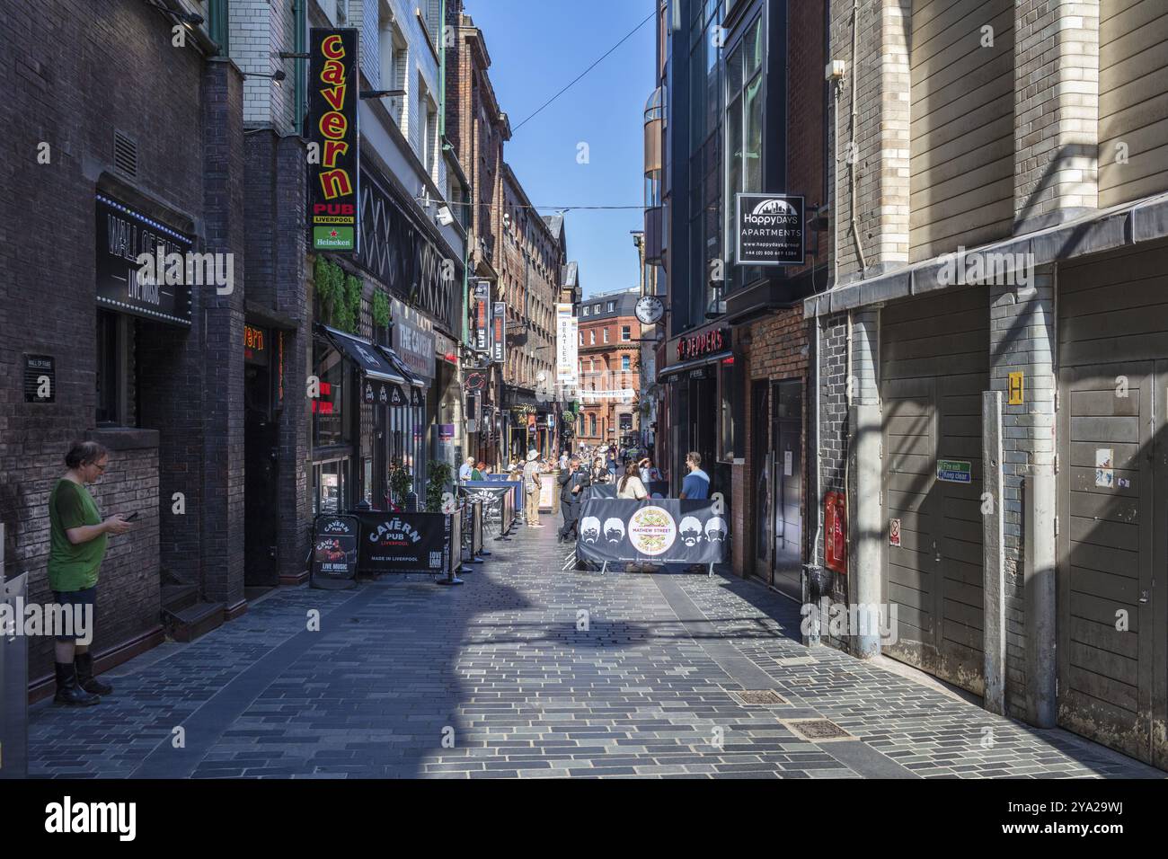 Narrow alley with shops and pubs, lively with passers-by, Liverpool ...