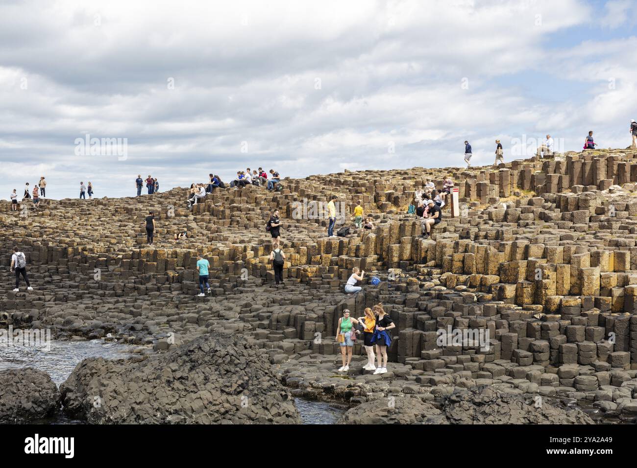 Groups of people on an impressive rock formation on the coast, Giant ...