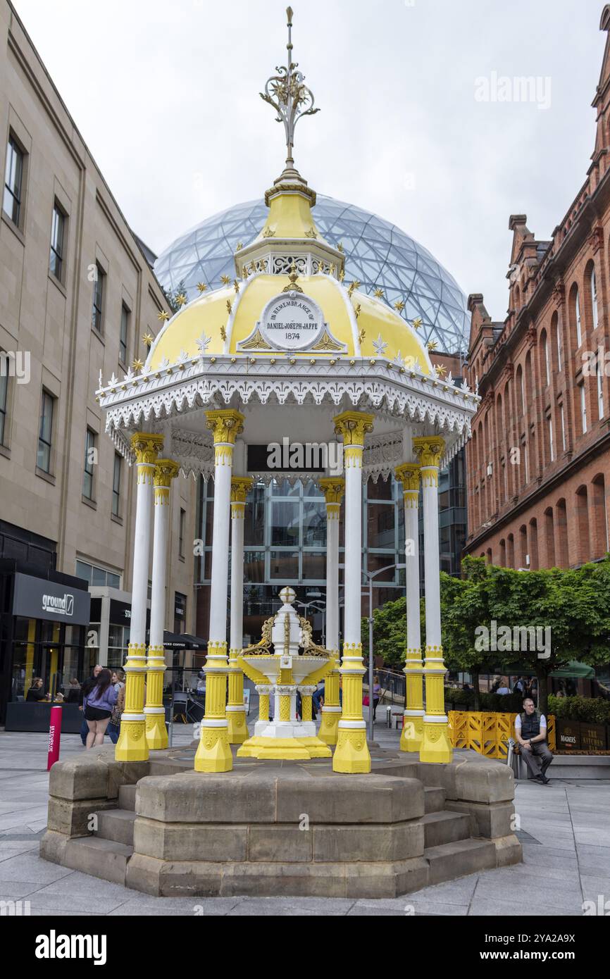 Yellow historic pavilion in a public square surrounded by old buildings ...