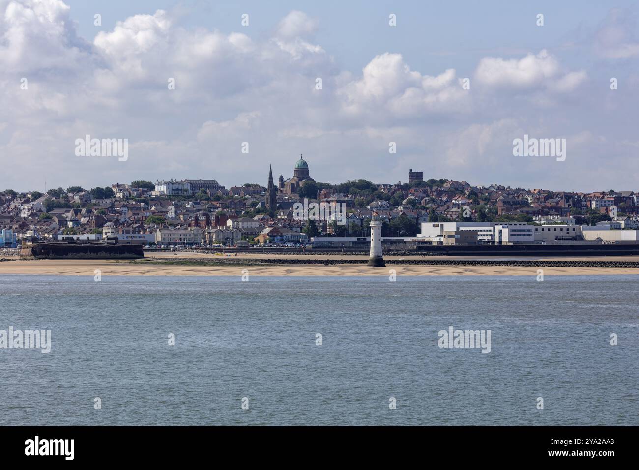Coastal view with a strip of beach and urban background with prominent ...