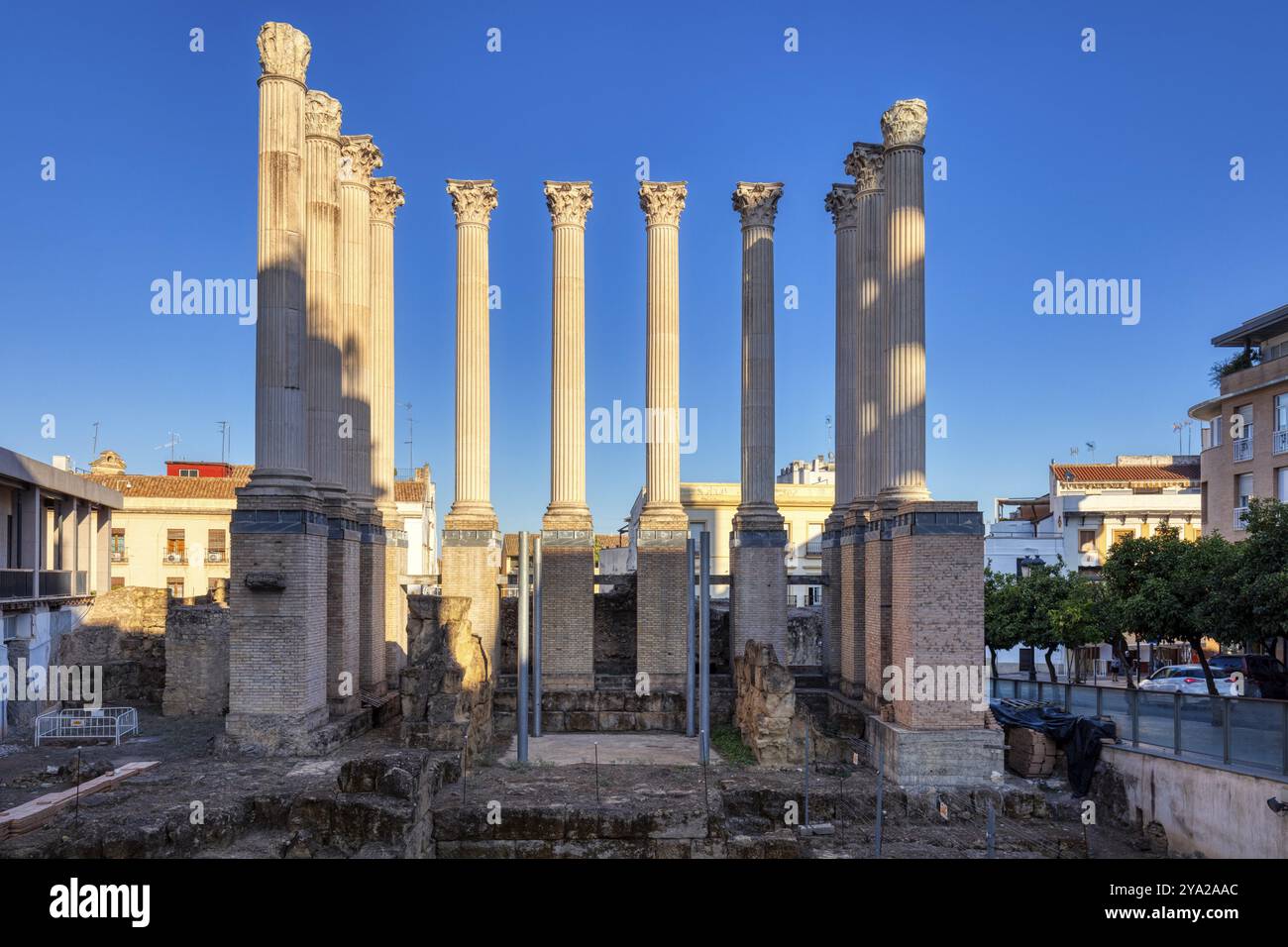 Ancient Roman temple columns under a clear sky, surrounded by modern ...