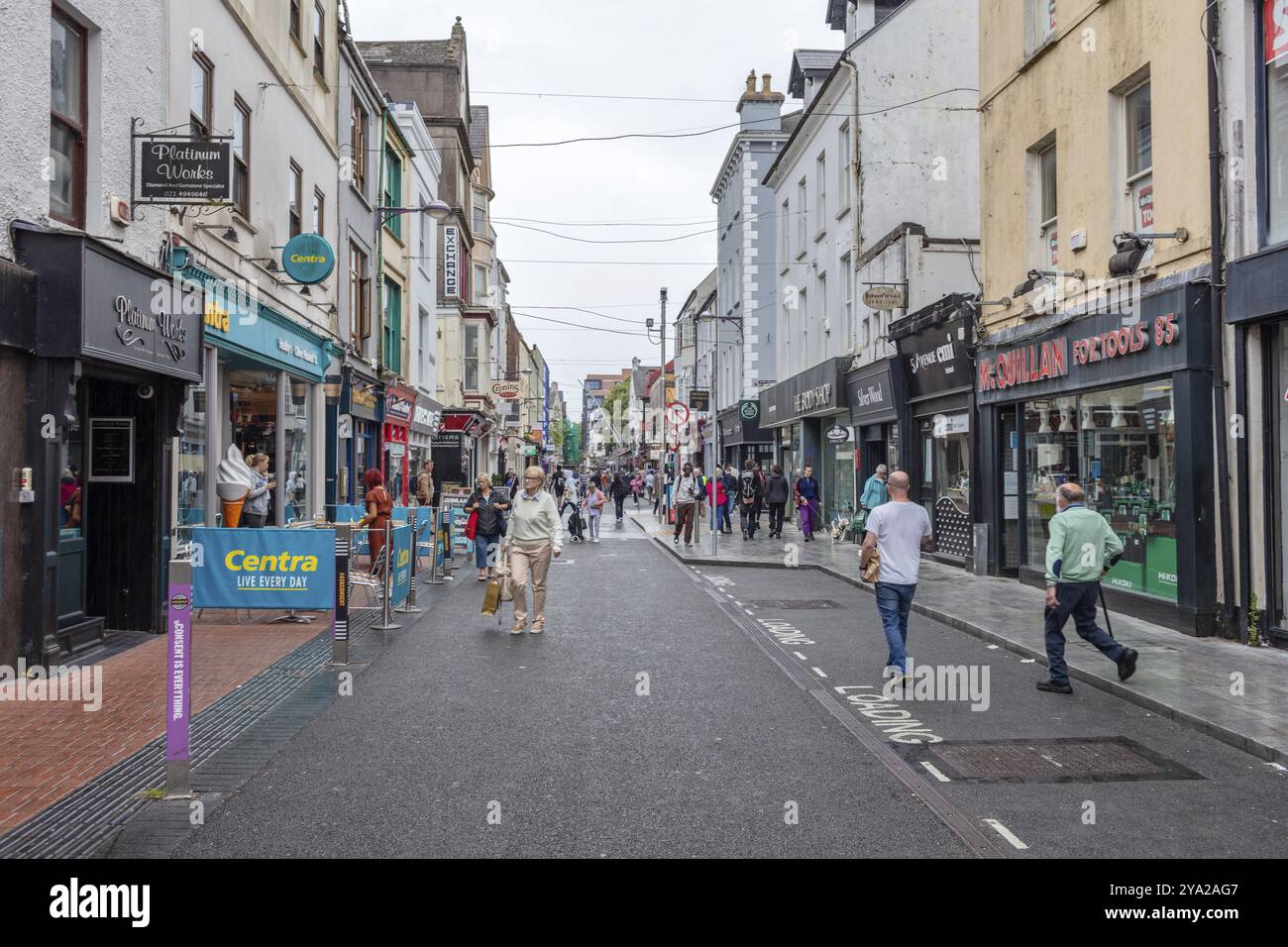 Busy shopping street with pedestrians and numerous shops, Cork Stock ...